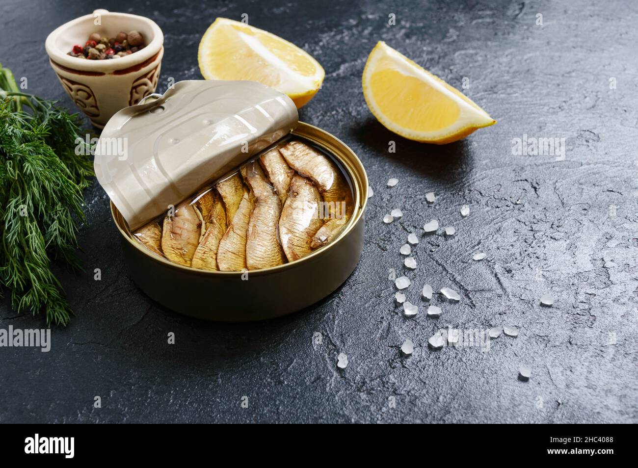 Baltic canned seafood fish sprats in a tin can with oil on dark ...