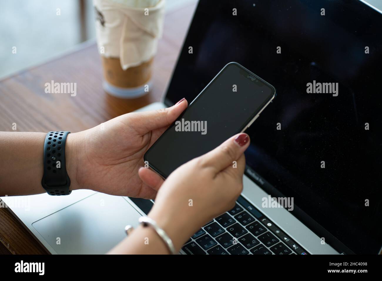 Women hand use smartphone with laptop background on table business ...