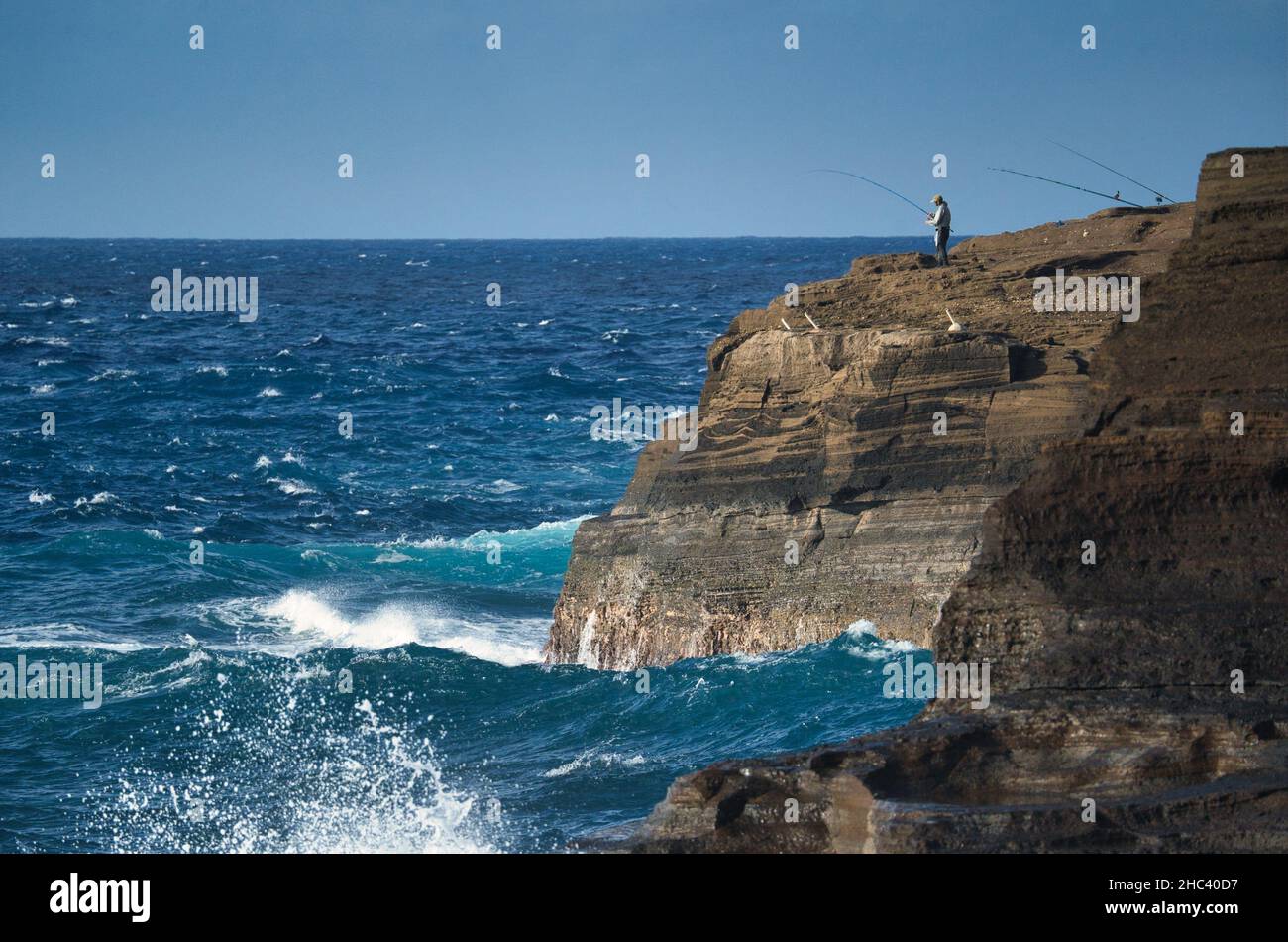 Fisherman fishing on a cliff near the sea Stock Photo - Alamy