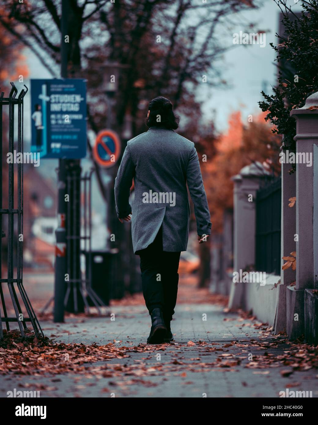 Vertical shot of the man walking down the street in autumn Stock Photo ...