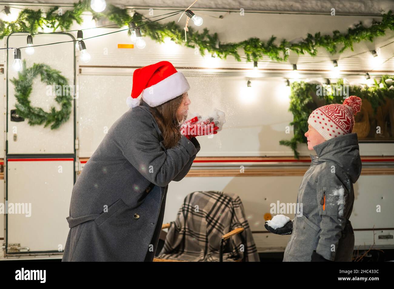 Caucasian woman playing snowballs with her son at the camper Stock ...