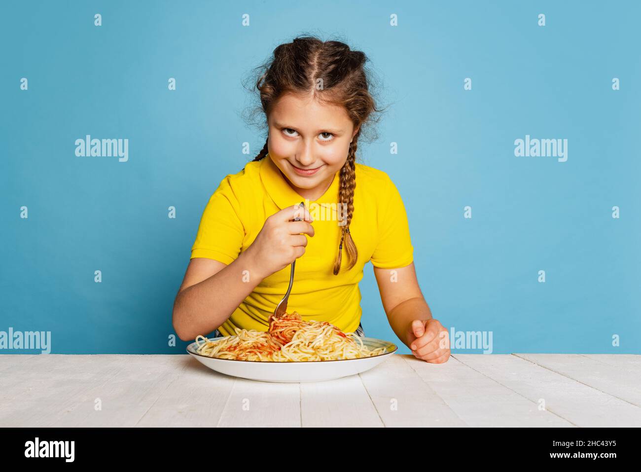 Cute little girl, emotive kid eating delicious Italian pasta isolated ...