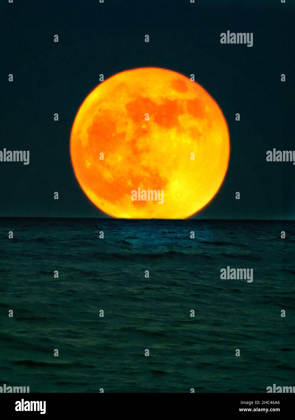 Vertical shot of a full moon on the sea Stock Photo - Alamy