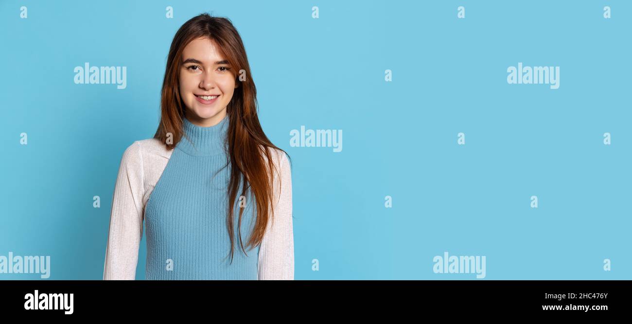 Smiling girl. Female half-length portrait isolated on blue studio ...