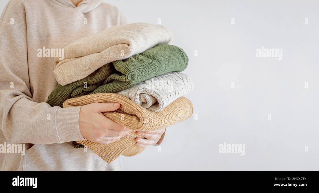 Woman's hand holding a stack of clothes. Clothes Donation, Renewable ...