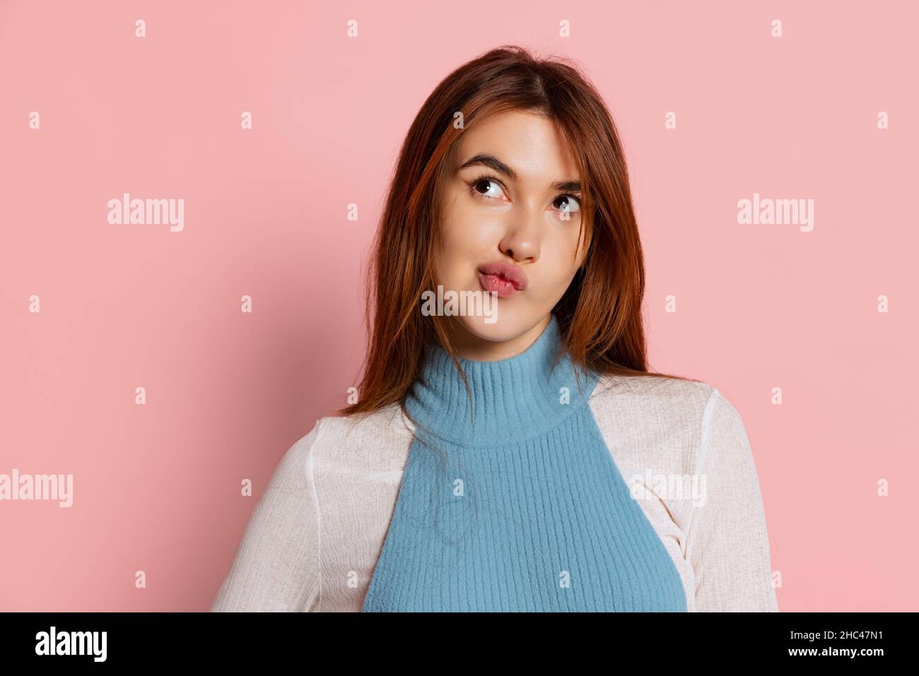 Cute young beautiful girl in warm blue neck-polo making fish face ...