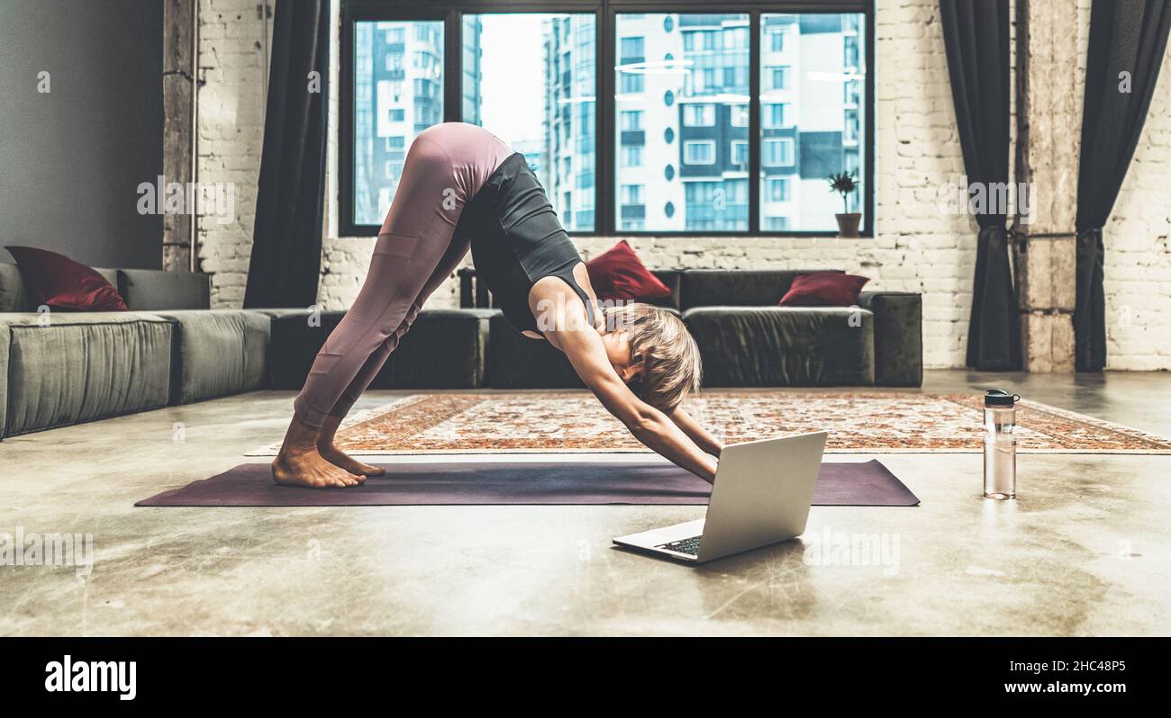 Nice Woman Practicing Yoga, Doing Down Dog Exercise, Watching Online ...