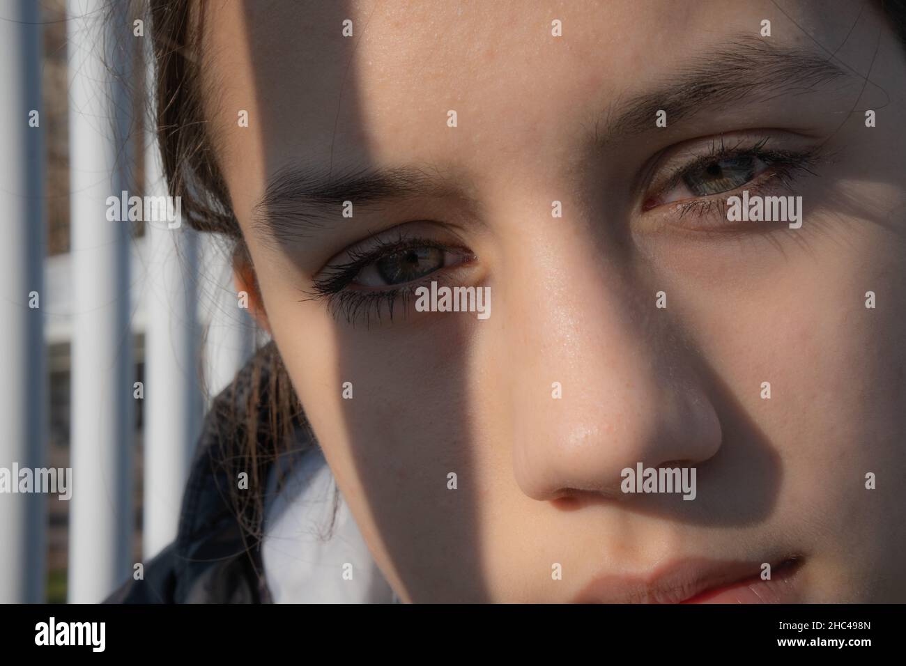 Human face cropped in an extreme close-up of a teenage girl staring ...