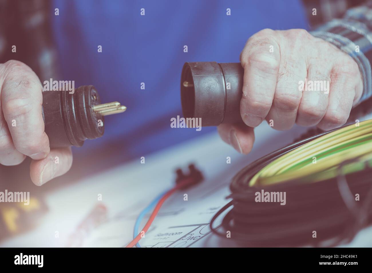 Electrician hands holding electrical plugs Stock Photo - Alamy