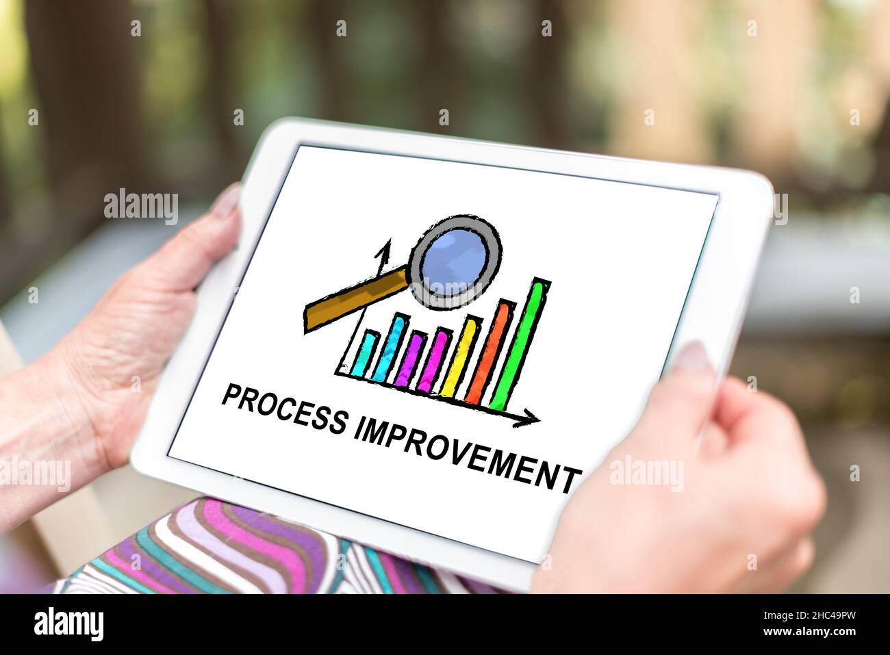 Female hands holding a tablet with process improvement concept Stock ...