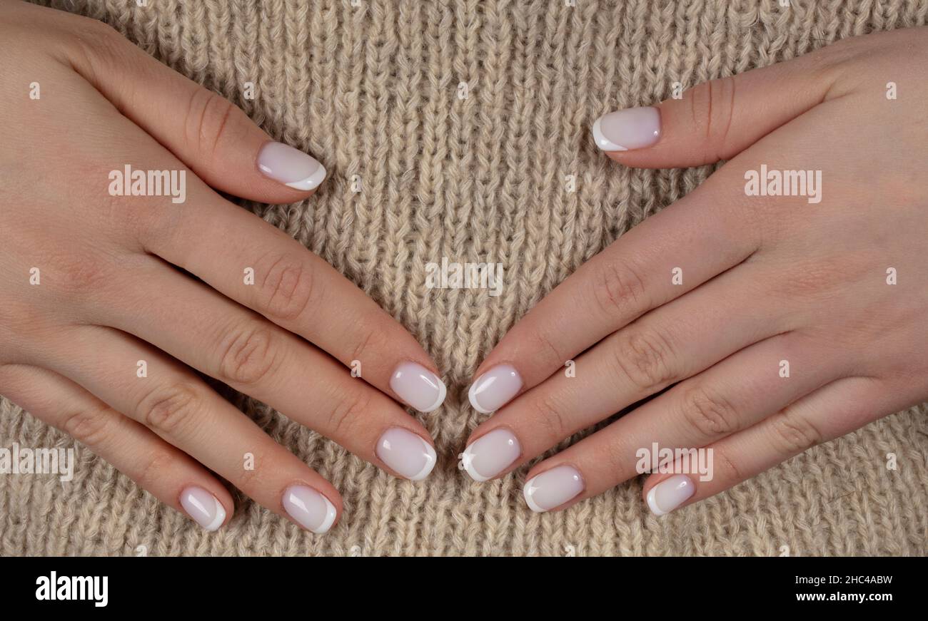 Classic white manicure on natural wool background Stock Photo - Alamy