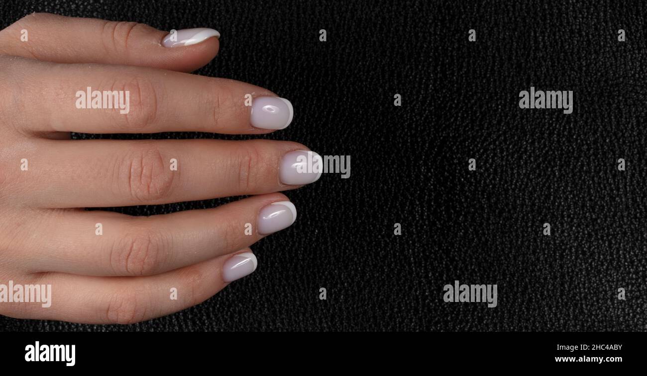 Classic white manicure on a dark background Stock Photo - Alamy