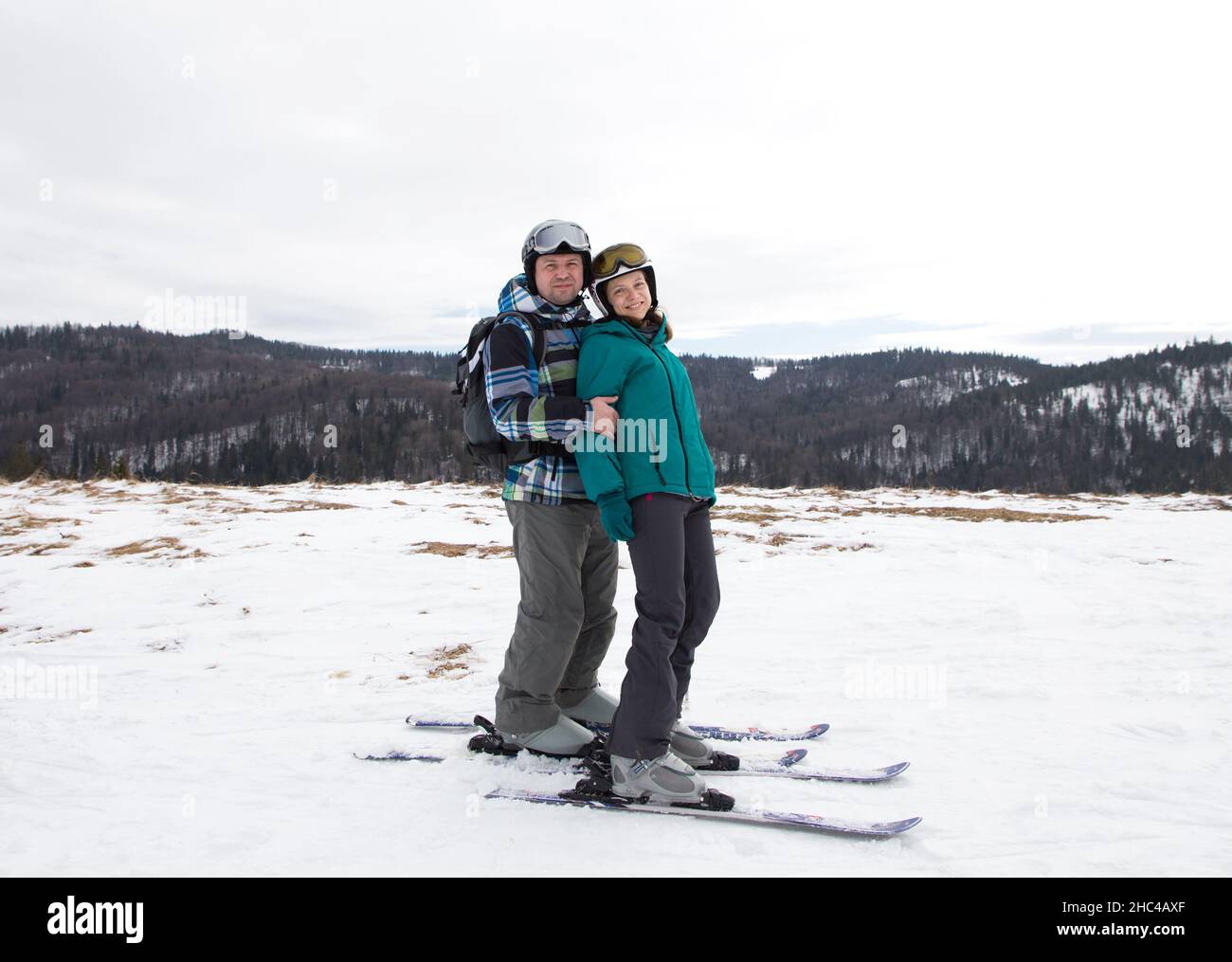 man and woman in love on skis on a snowy mountain slope. Holidays at ...