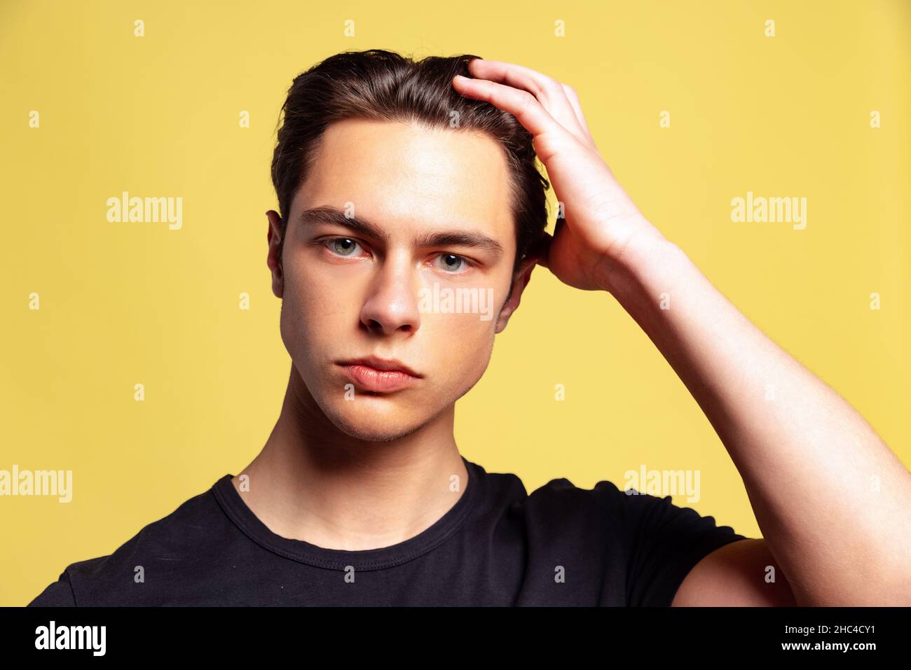 Close-up portrait of young handsome muscle man in black t-shirt looking ...