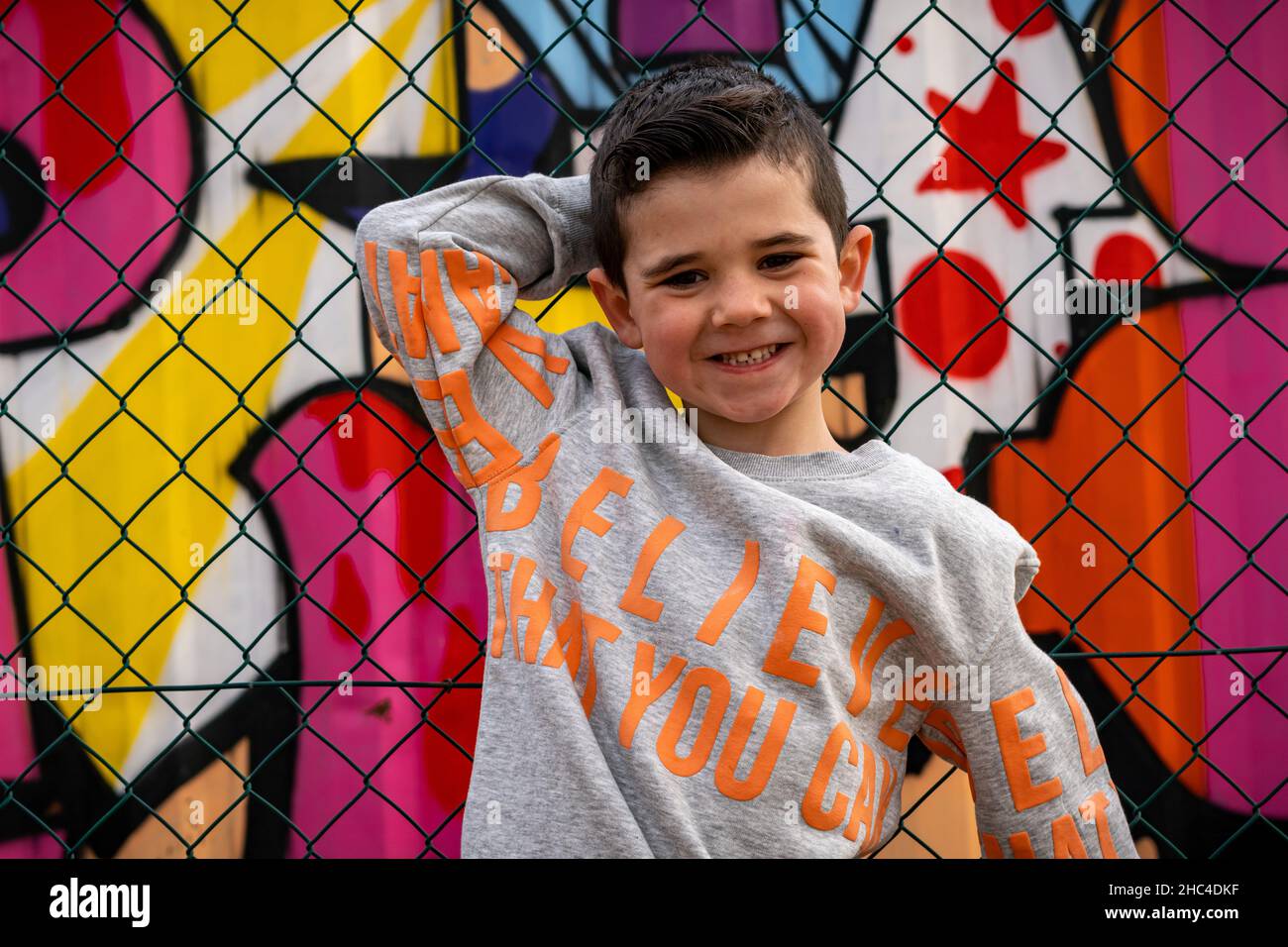A young kid posing his best and smiling and trying to be a model for ...