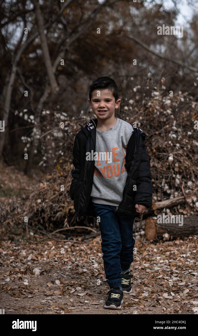 A young kid posing his best and smiling and trying to be a model for ...