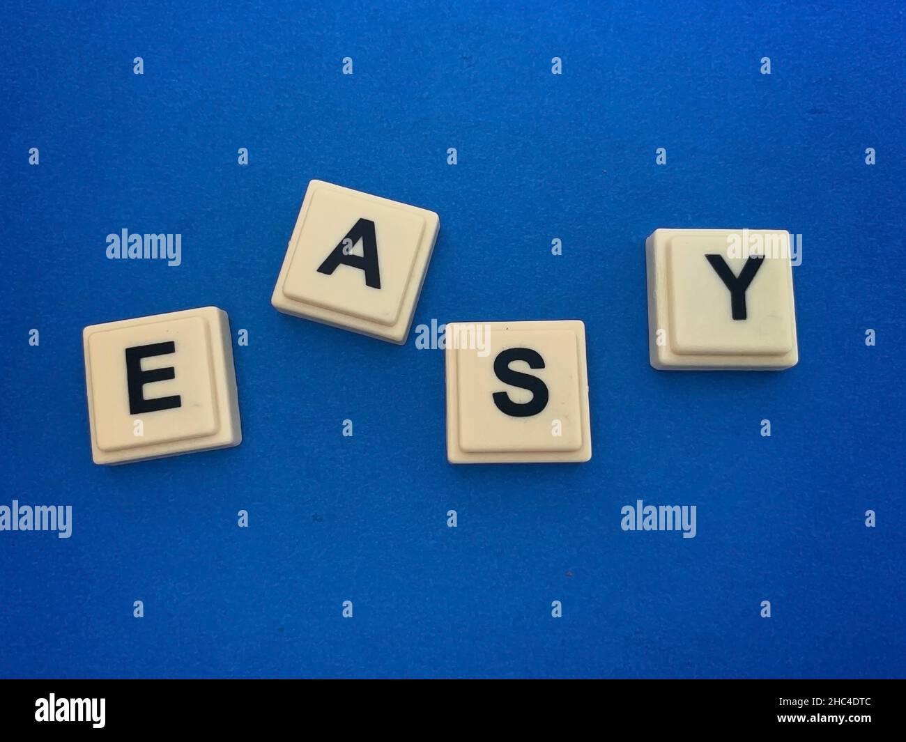 Word EASY on cube blocks with dark blue background Stock Photo - Alamy