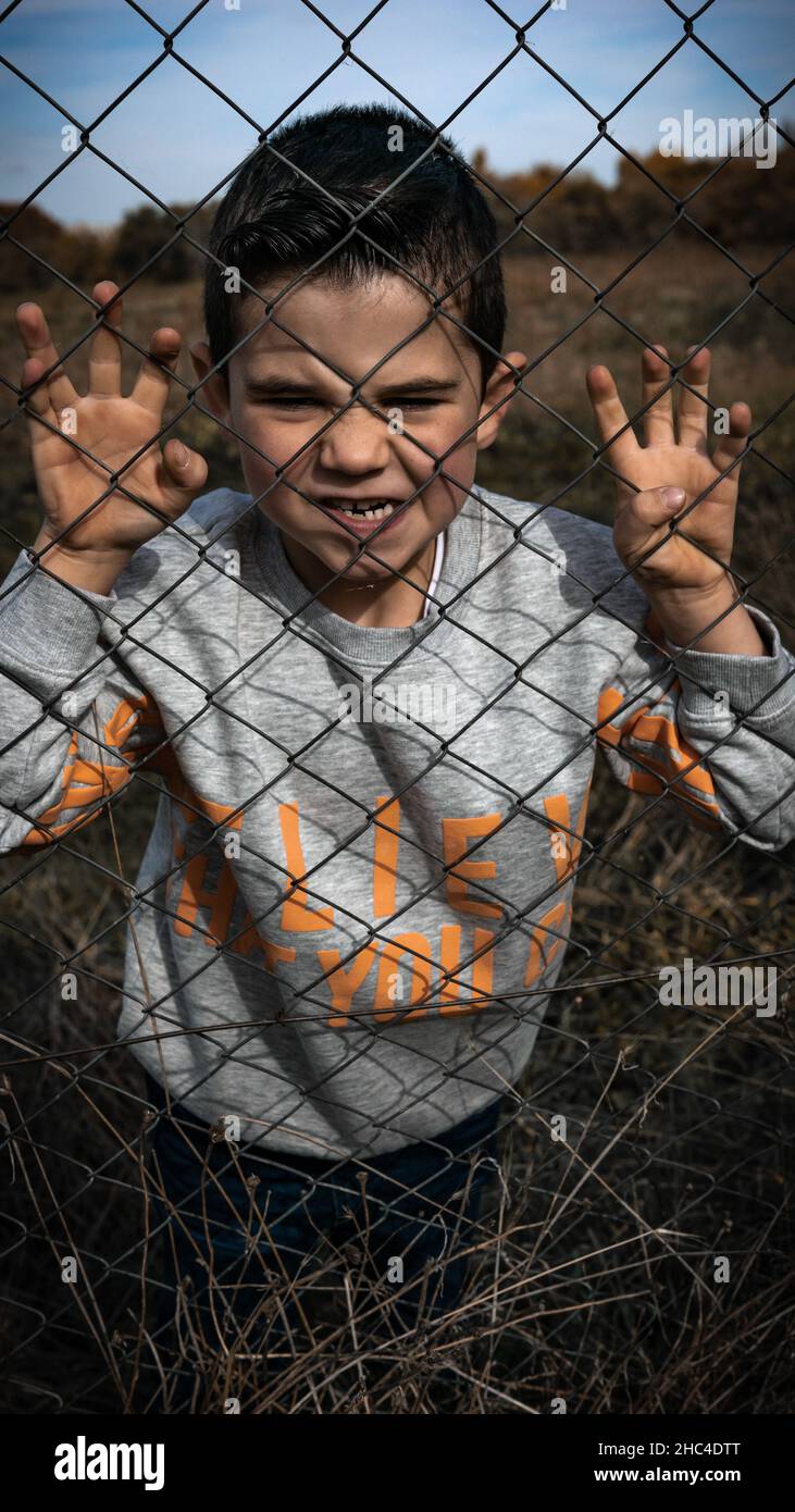 A young kid posing his best and smiling and trying to be a model for ...