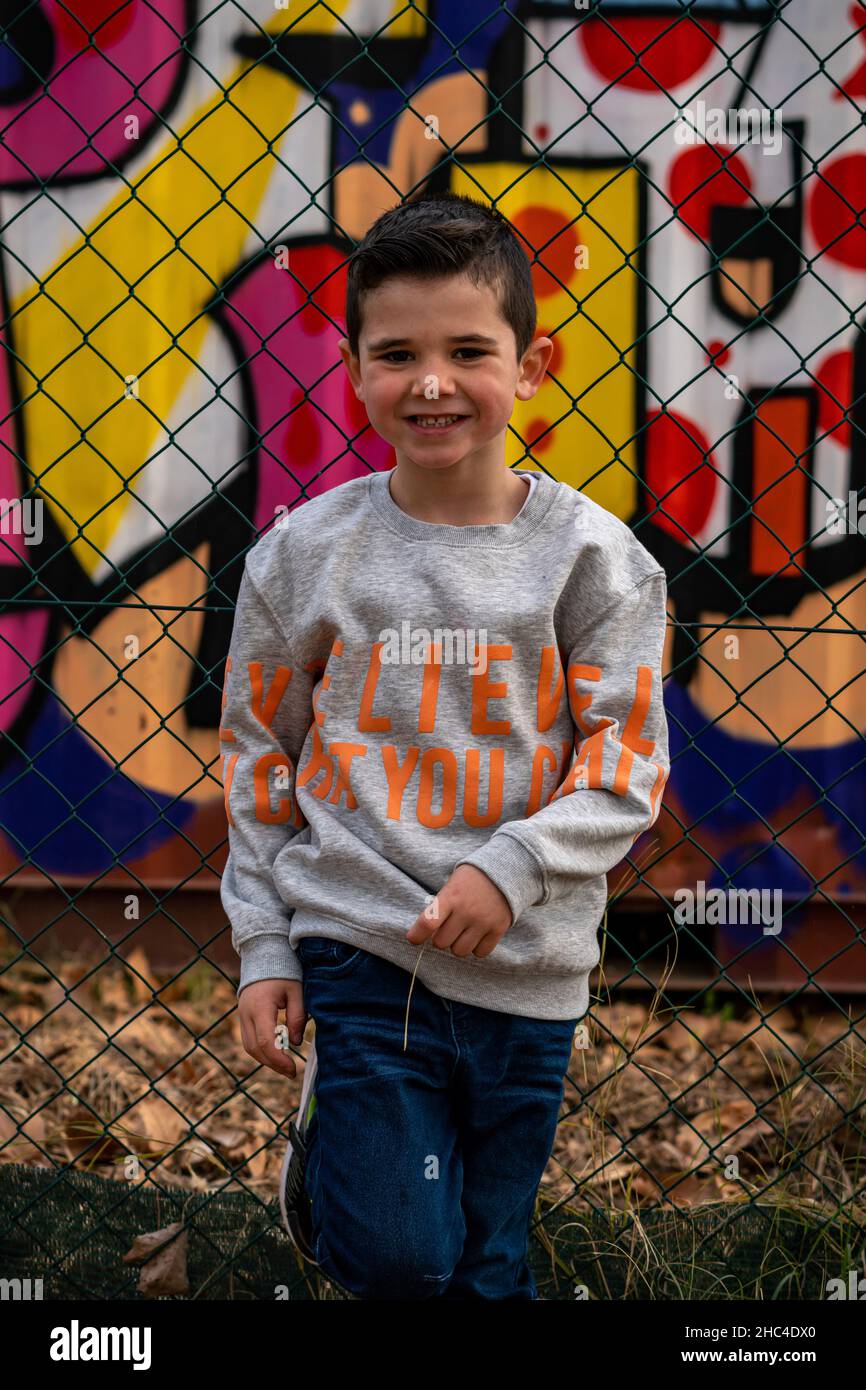 A young kid posing his best and smiling and trying to be a model for ...