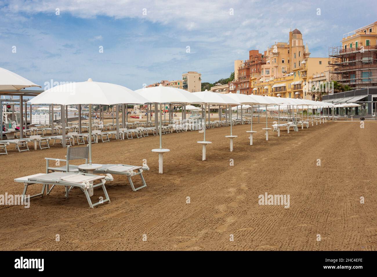 White parasols, sun beds and freshly combed sand at the beach. Morning ...
