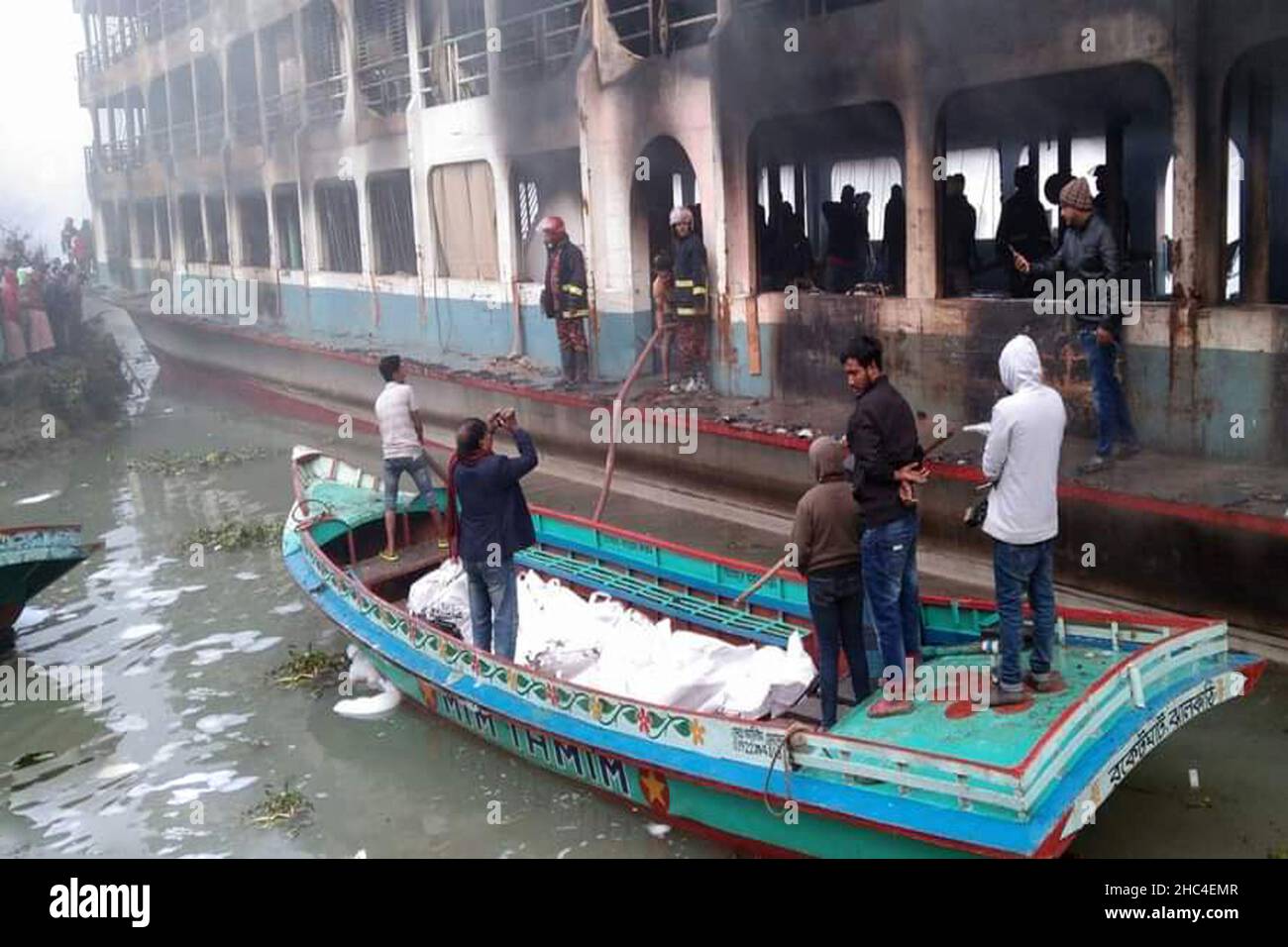 Jhalokati. 24th Dec, 2021. Rescuers work at the fire site on a ferry in ...