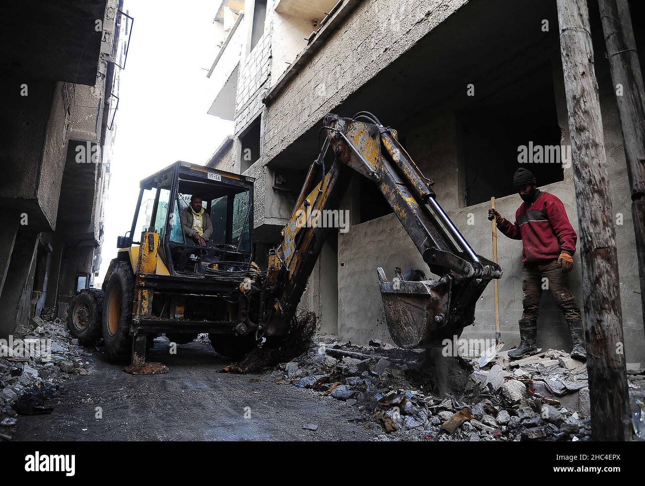 Damascus, Syria. 23rd Dec, 2021. A worker operates an excavator to ...