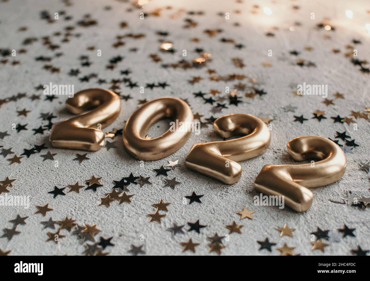 Close-up photo of golden number 2022 on concrete surface sprinkled with ...
