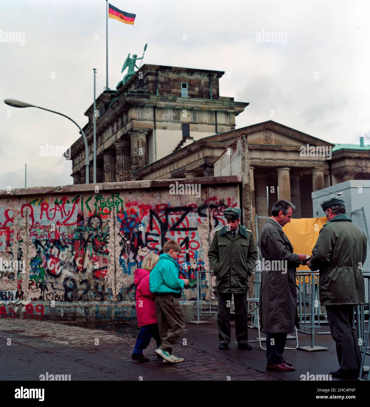 Man and children crossing into East Berlin at the Brandenburg Gate ...
