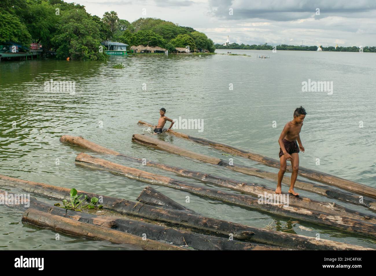 Burmese youth boys swimming and playing in Taungthaman Lake, close to U ...