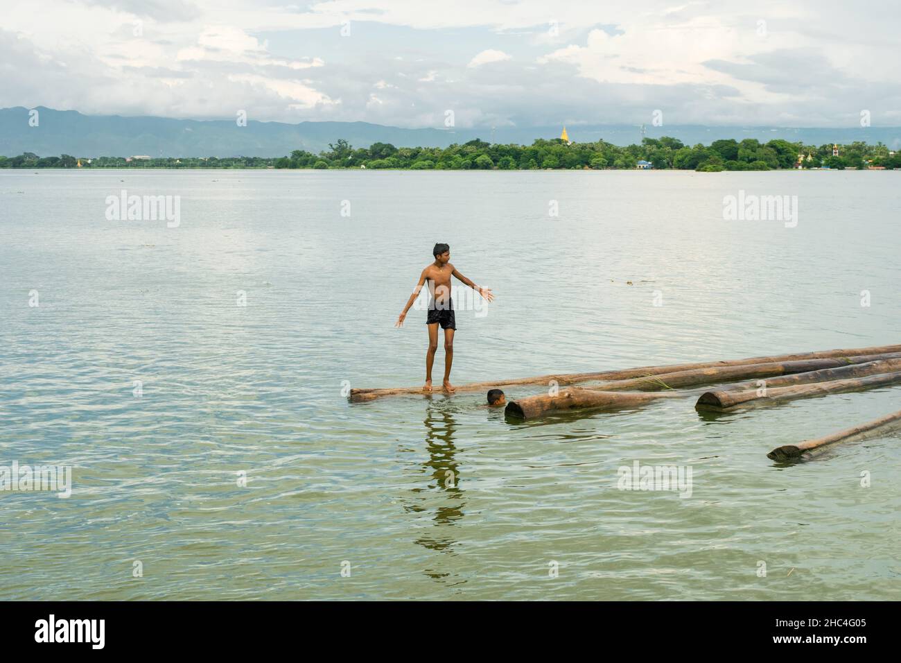 Burmese youth boys swimming and playing in Taungthaman Lake, close to U ...