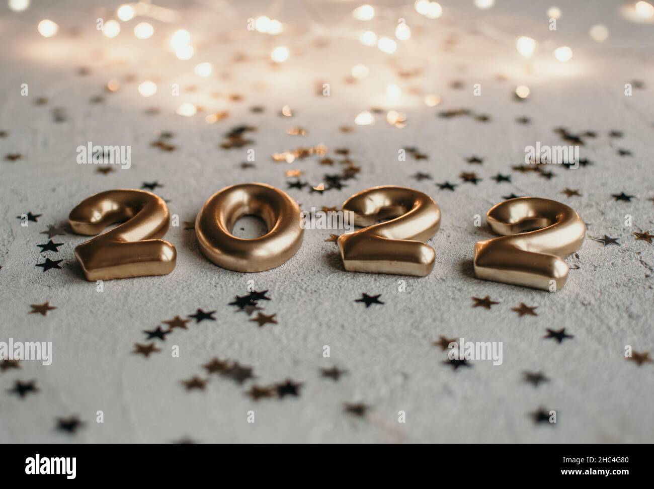 Close-up photo of golden number 2022 on concrete surface sprinkled with ...