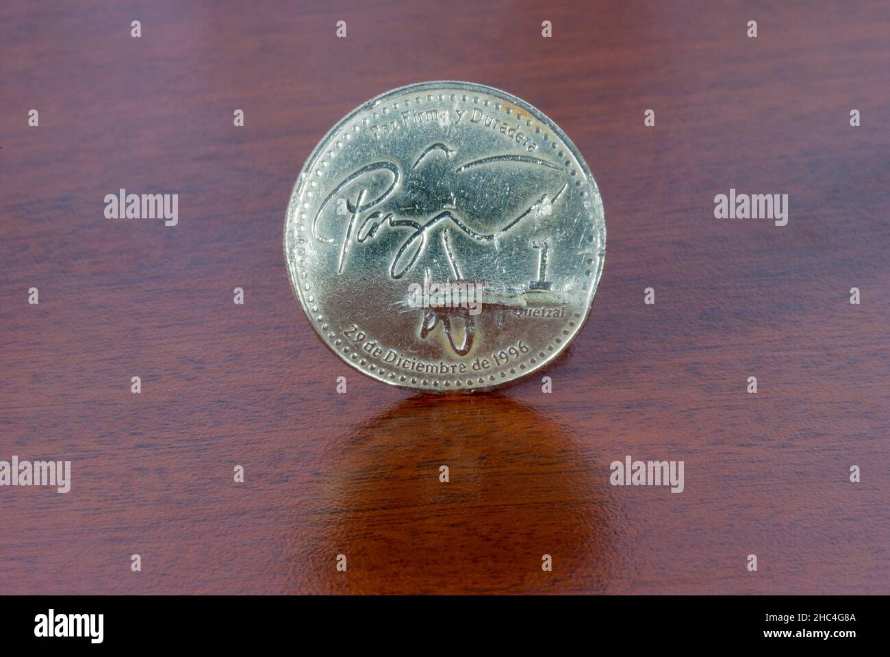 Broken coin from one Quetzal, Guatemala, 2001, on wood texture Stock ...