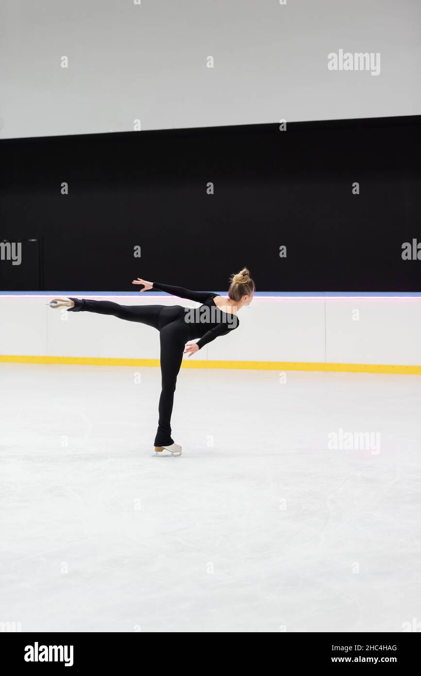 back view of professional figure skater in black bodysuit skating with ...