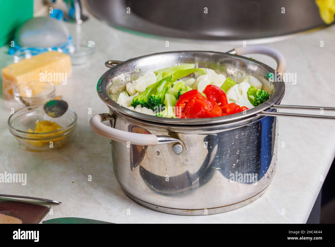 chopped boiled vegetables in colander in stainless steel cooking pot ...