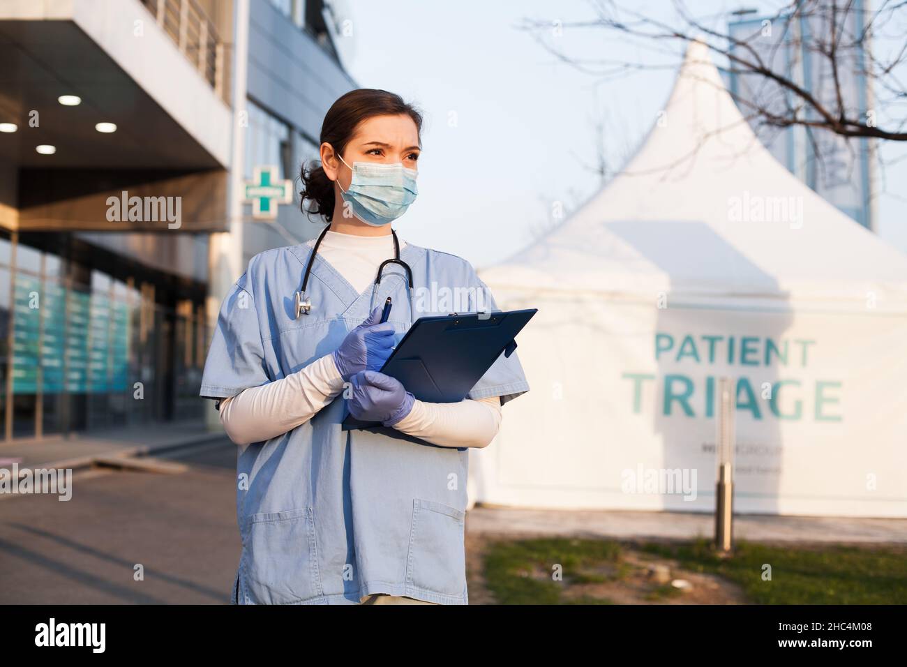 Young beautiful caucasian female NHS doctor in front of emergency ...