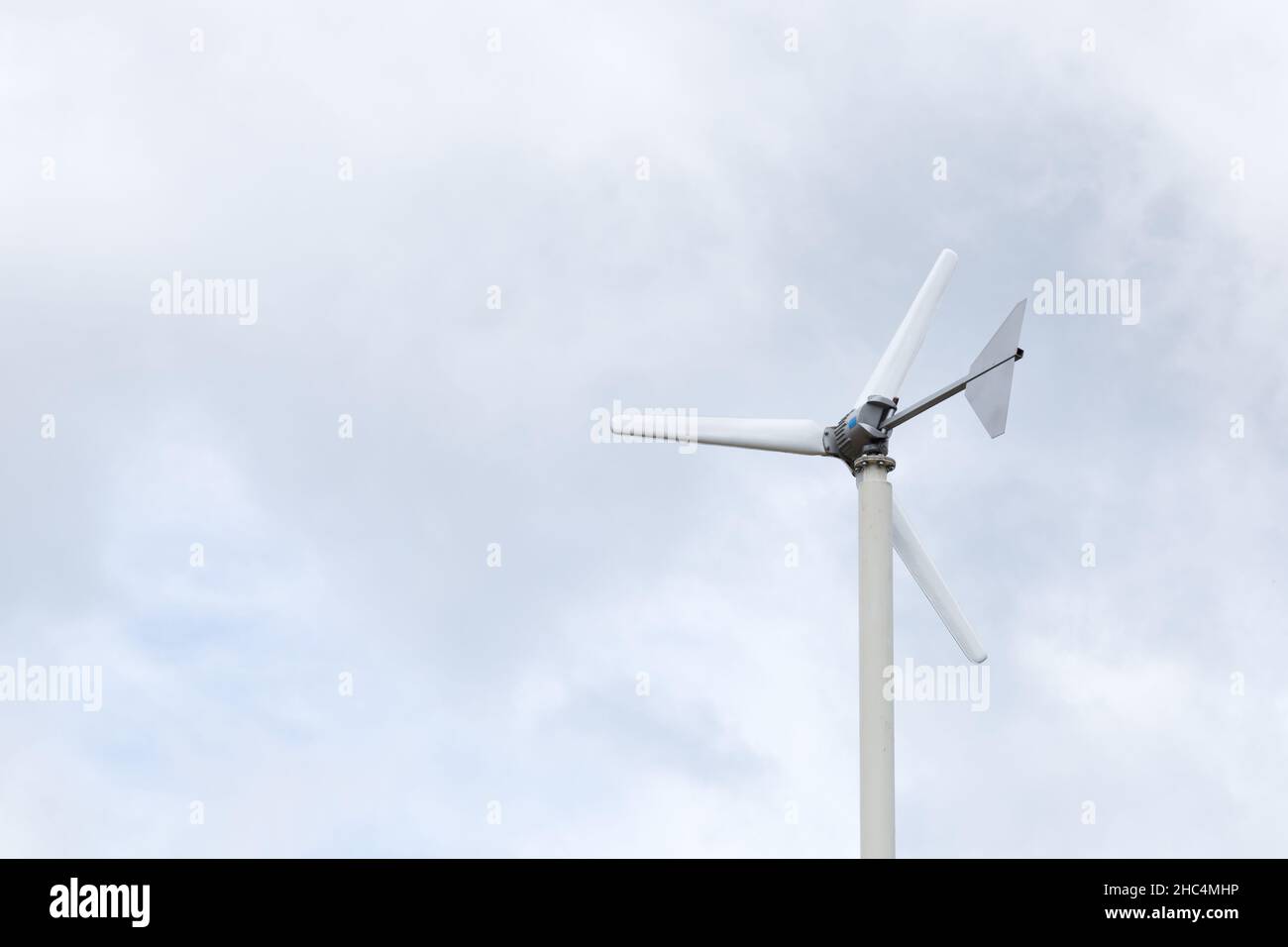 White wind turbines. The electricity produced by wind power Stock Photo ...