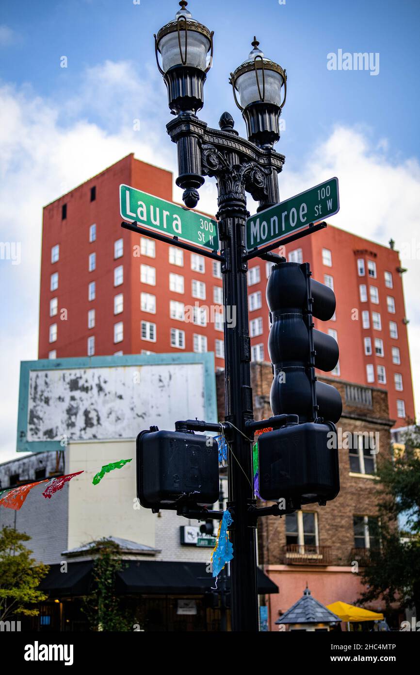 Vertical shot of a lantern pole with street signs and traffic lights in ...