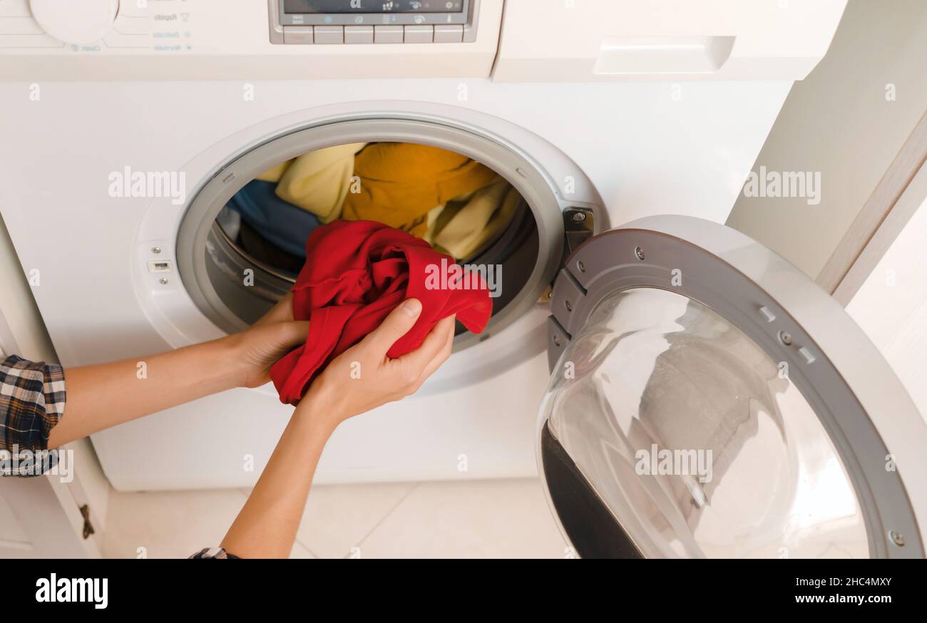 Woman puts bright clothes into a washing machine Stock Photo - Alamy