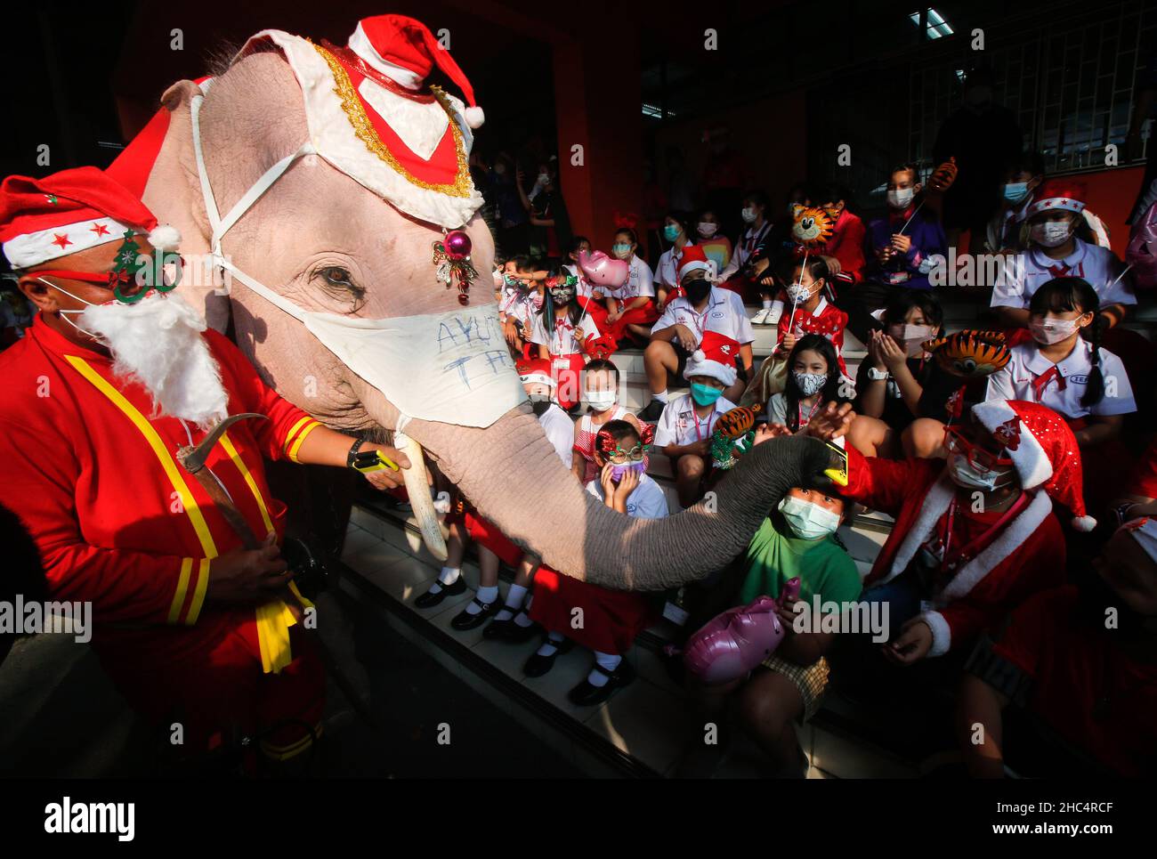 Ayutthaya, Thailand. 24th Dec, 2021. Students receive gifts from an ...
