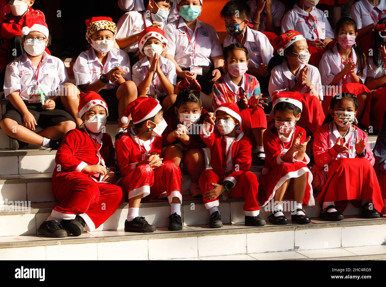 Students dressed in Santa Claus costumes pose for a group photo during ...