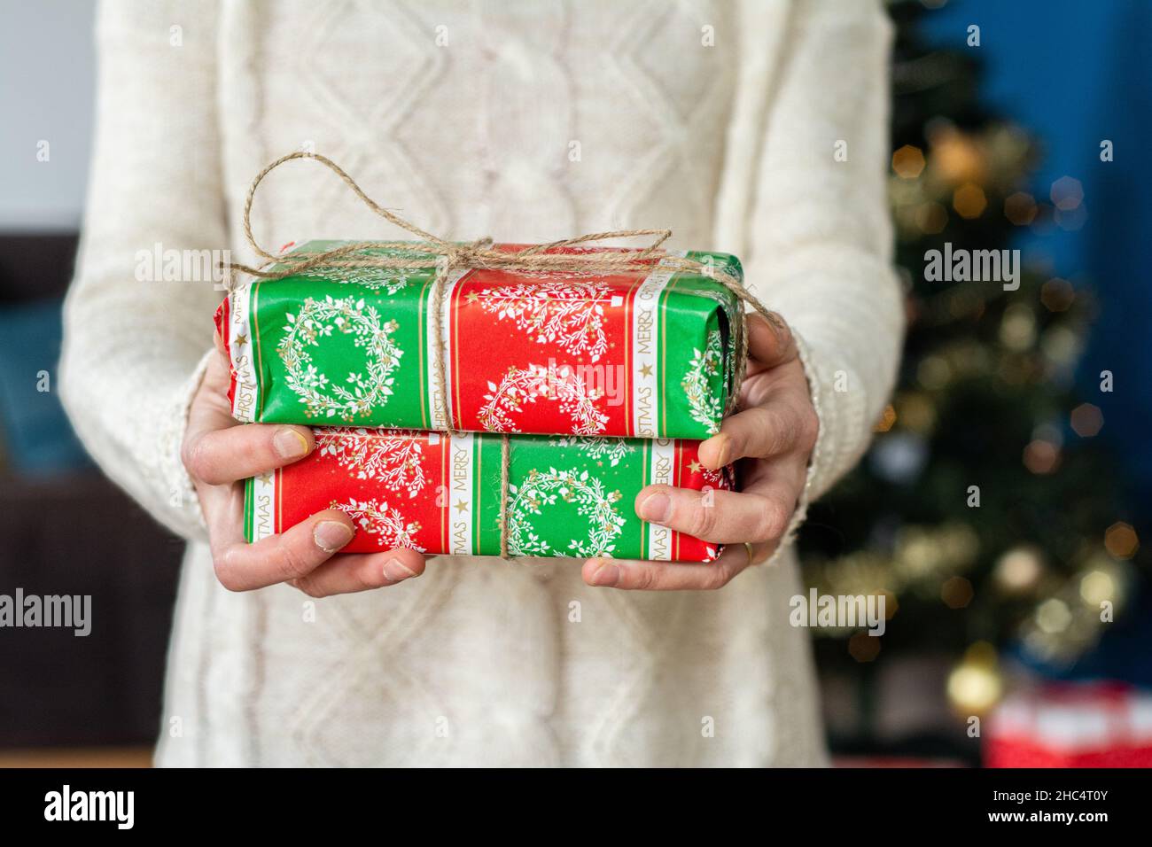 gift giving woman hand holding a gift box in a gesture of giving ...