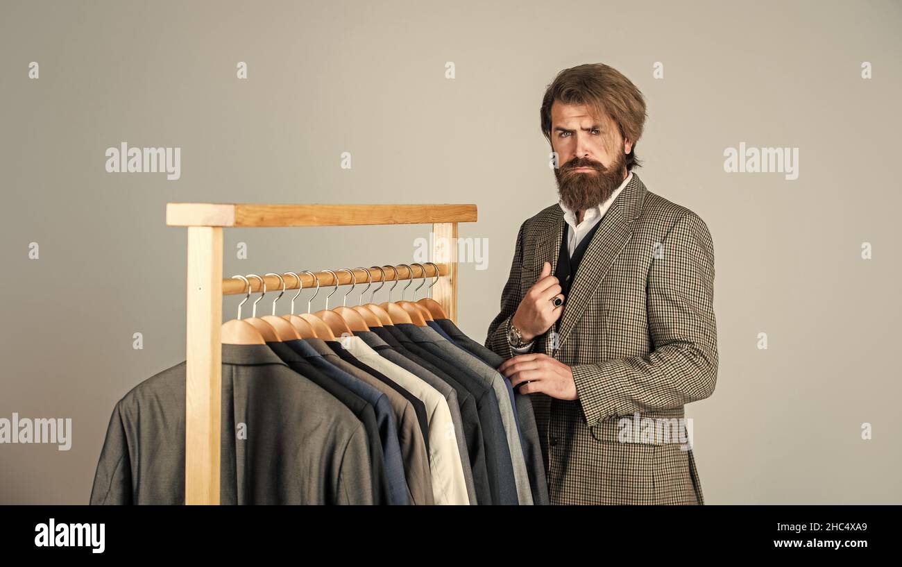 Businessman handsome guy in clothes shop choosing garments, menswear ...