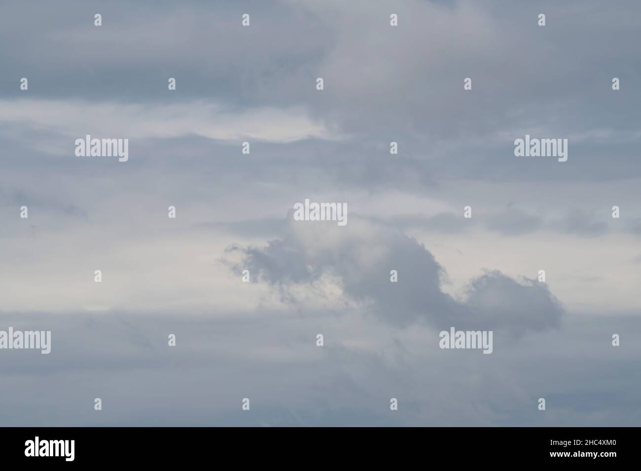 A gray cloudy sky, with layers of clouds and a single unique cloud in ...