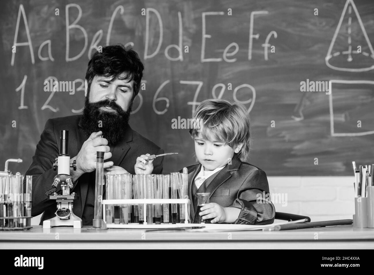 teacher man with little boy. school kid scientist studying science ...