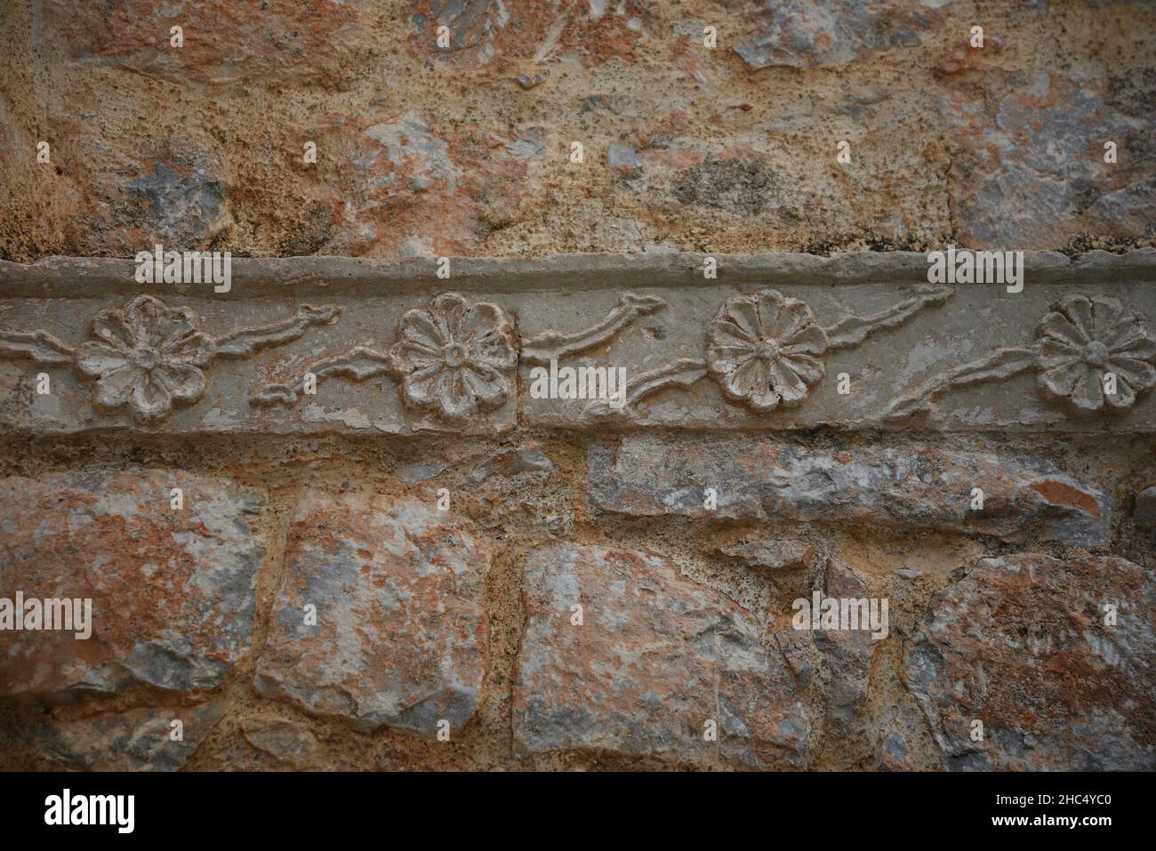 Traditional stone built wall with a handmade flower filigree listello ...