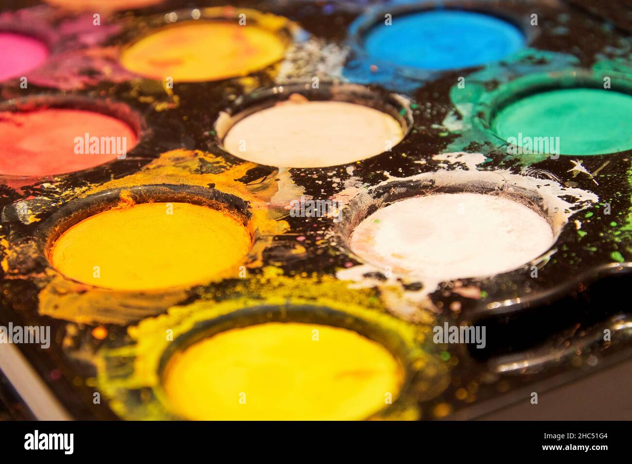 Close-up perspective view of a messy palette with watercolor paints ...