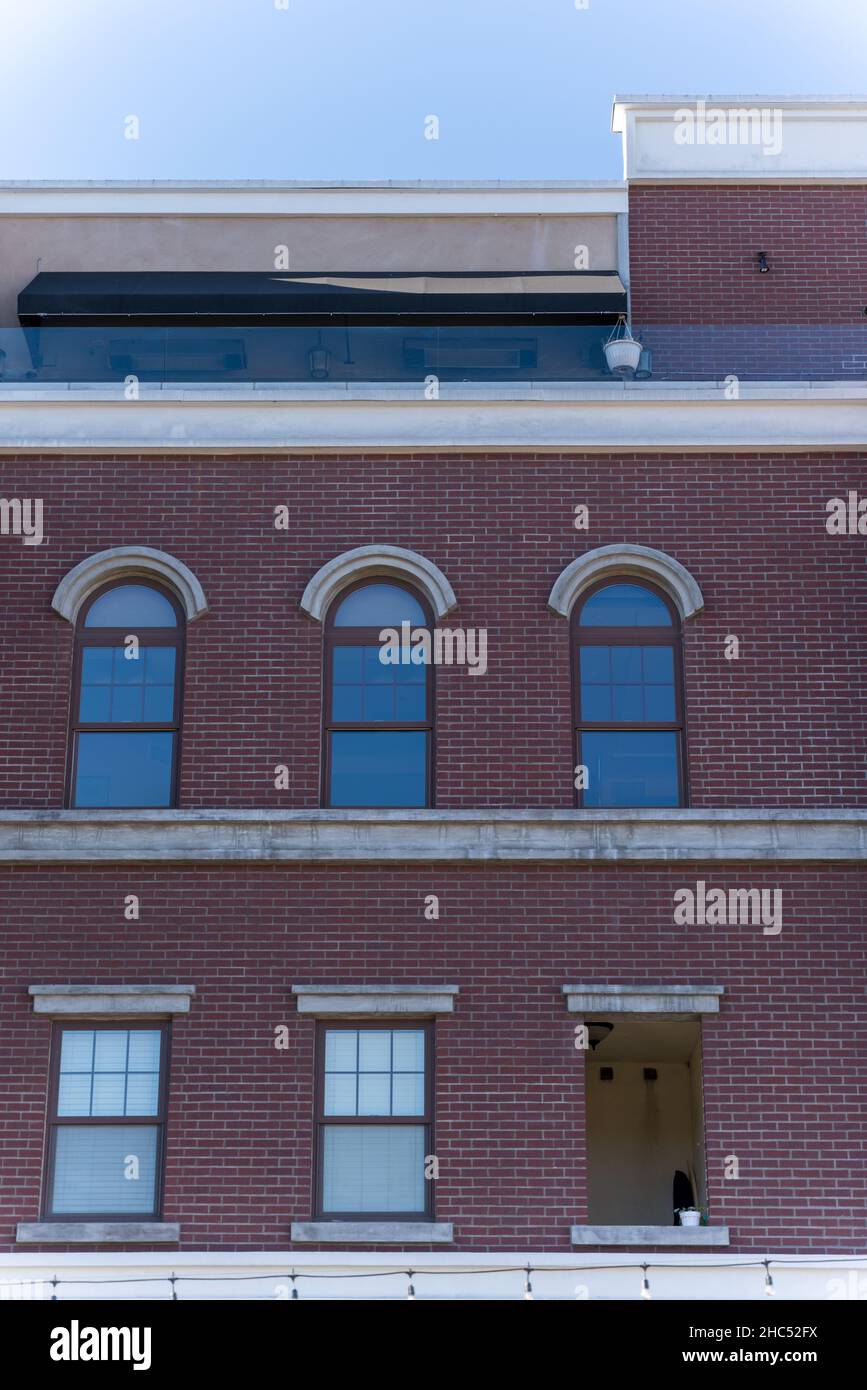 Vertical shot of a tall brick building with a one open window Stock ...