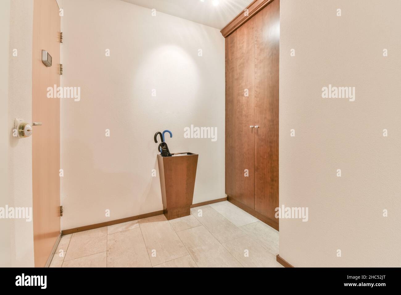 Hallway room with wooden cabinet and urn for umbrella Stock Photo - Alamy