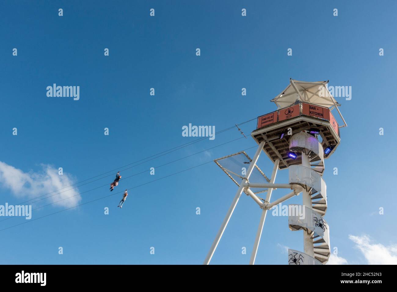 "The Zip" zipwire attraction (riders blurred) on Brighton beach ...