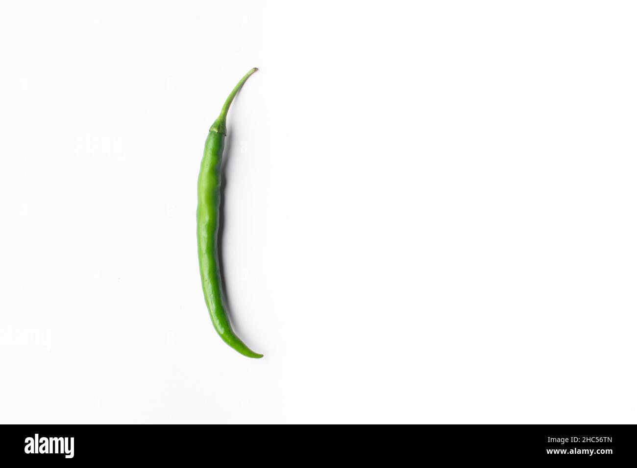 Single green chilli pepper isolated in white background with copy space ...